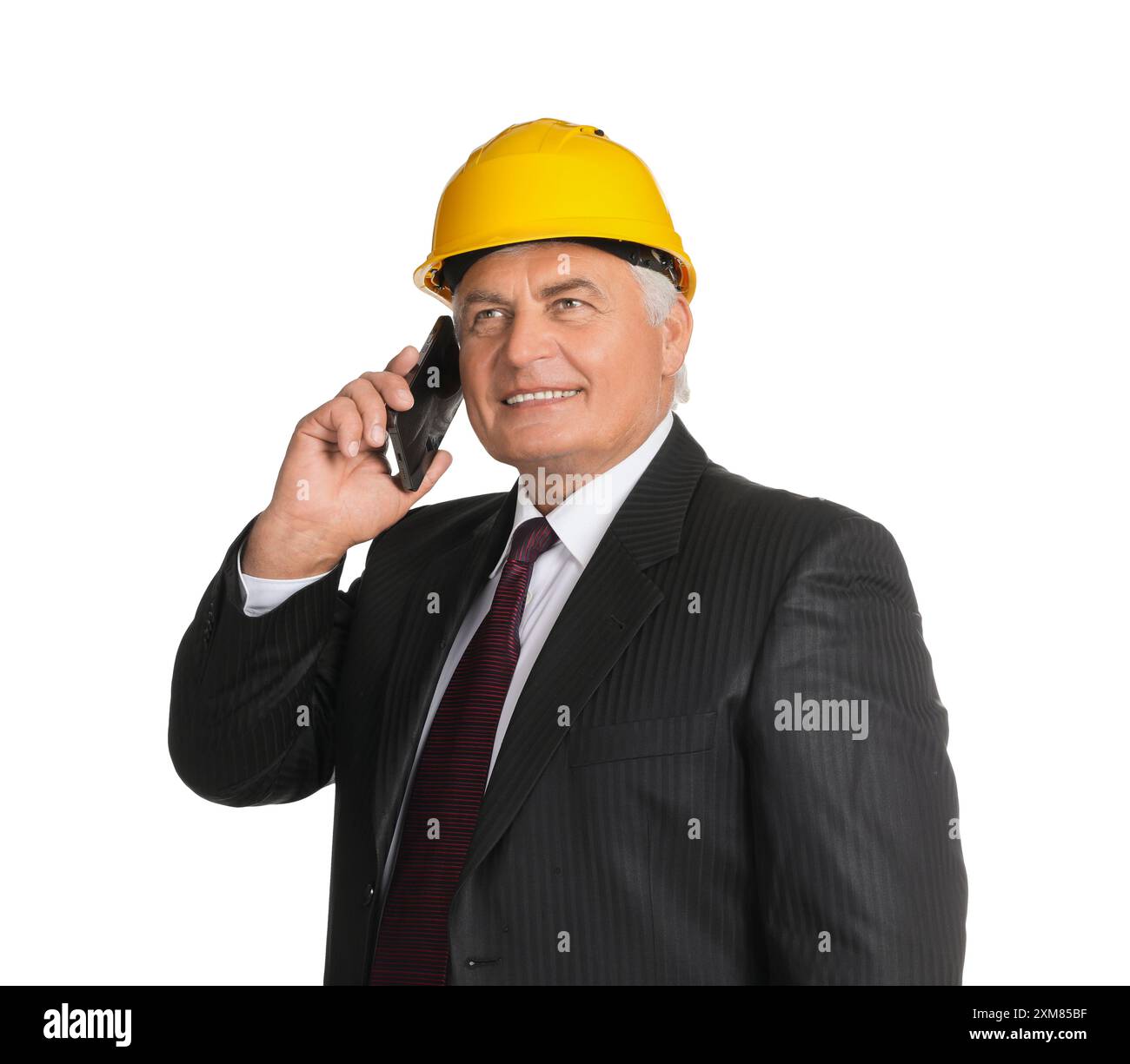 Engineer in hard hat talking on smartphone against white background ...