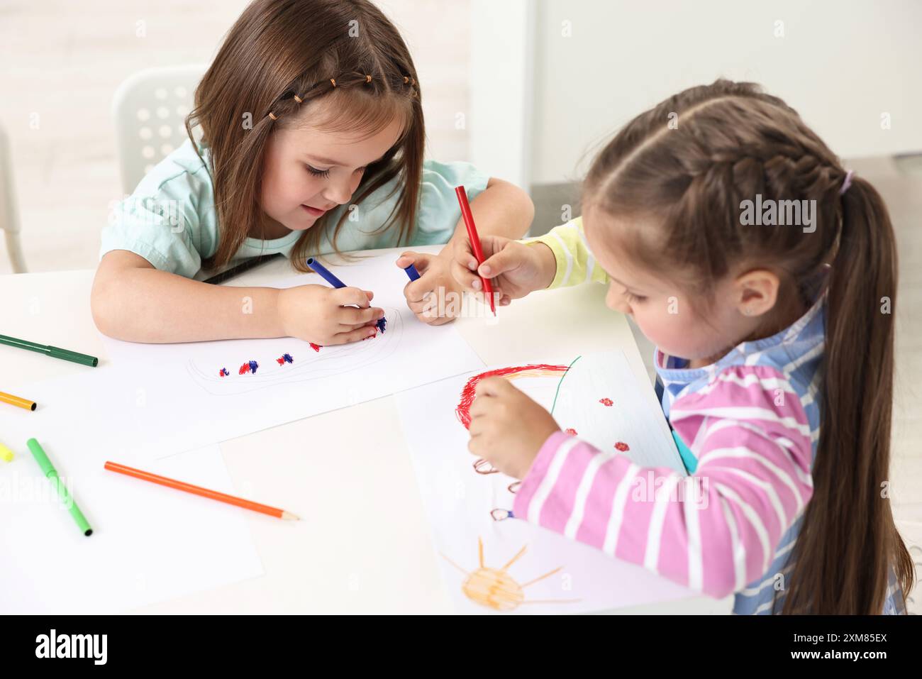 Cute little children drawing at table indoors Stock Photo - Alamy