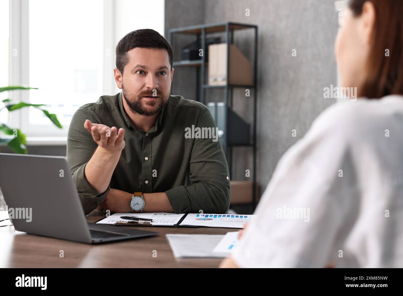 Consultant working with client at table in office Stock Photo - Alamy