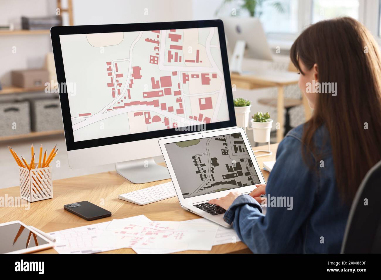 Cartographer working with cadastral maps at table in office Stock Photo ...