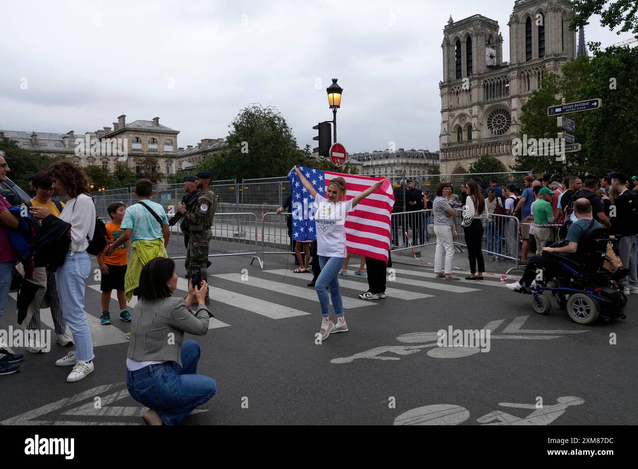 Estella, from the U.S., poses for pictures with the American flag as ...