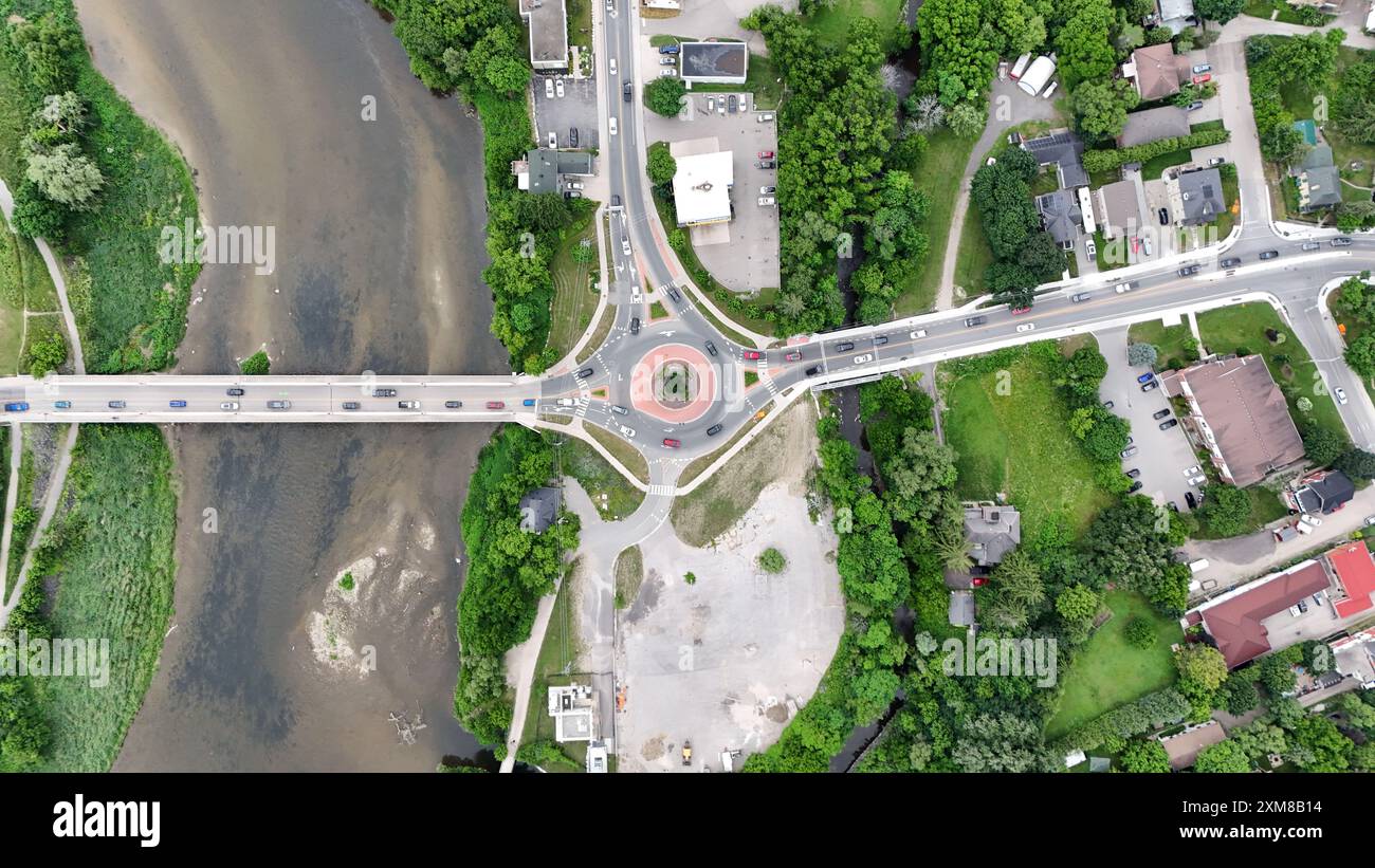 An aerial view of a roundabout with a bridge crossing a river ...
