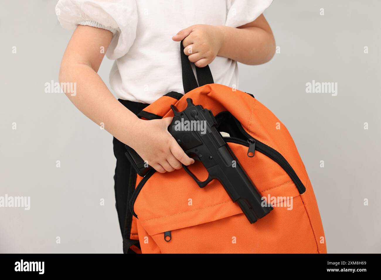 Child with gun and backpack in classroom, closeup. School shooting ...