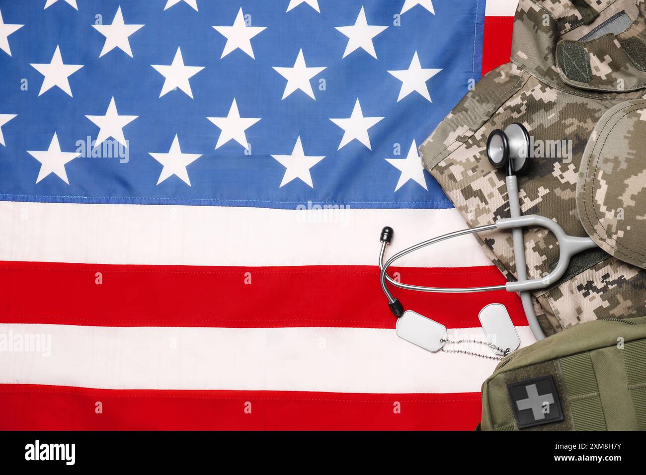 Stethoscope, first aid kit, tags and military uniform on USA flag, top ...