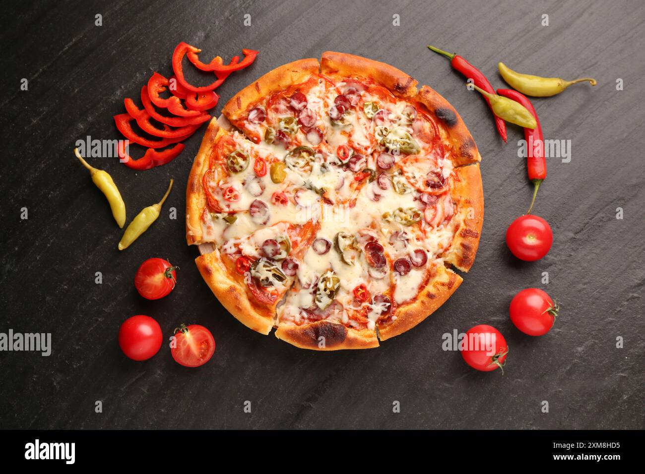 Delicious pizza Diablo among products on dark textured table, flat lay ...