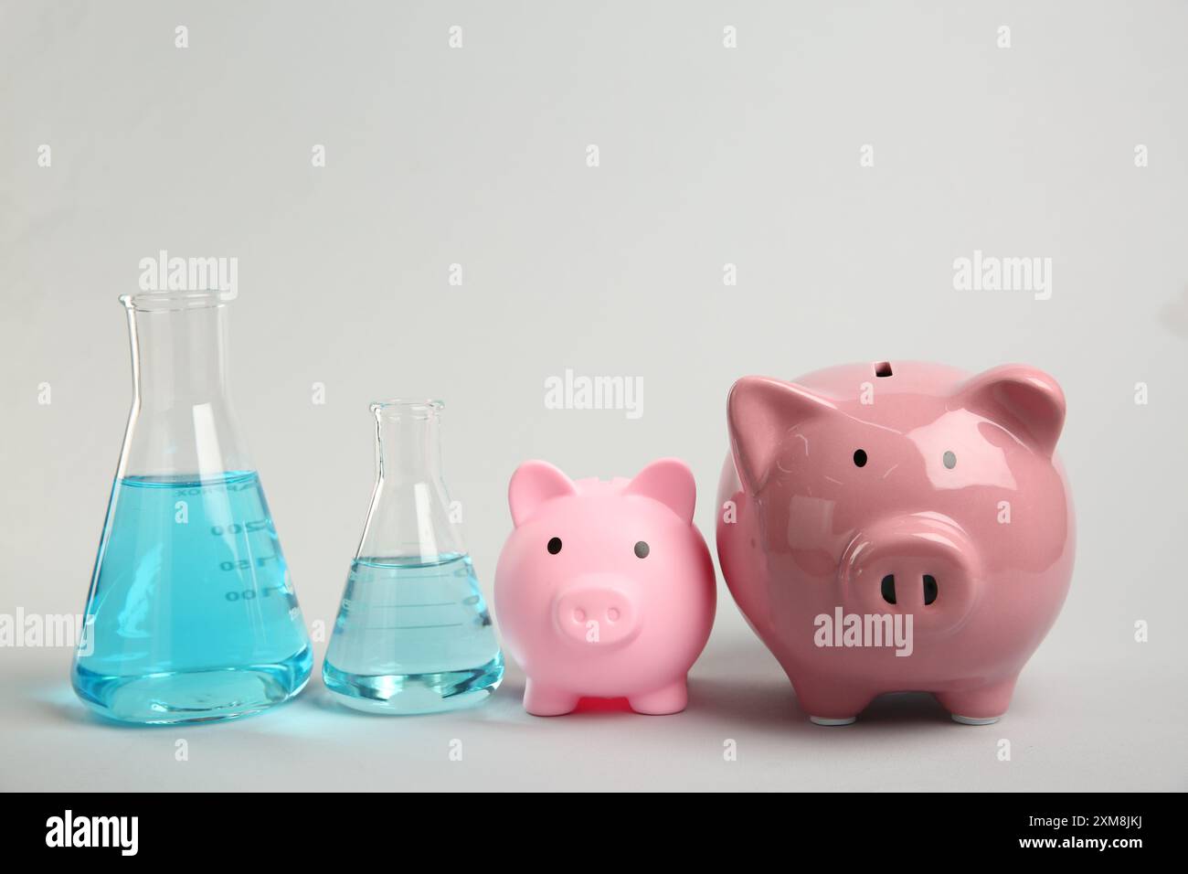 Water save concept. Piggy banks and laboratory glassware with liquid on ...