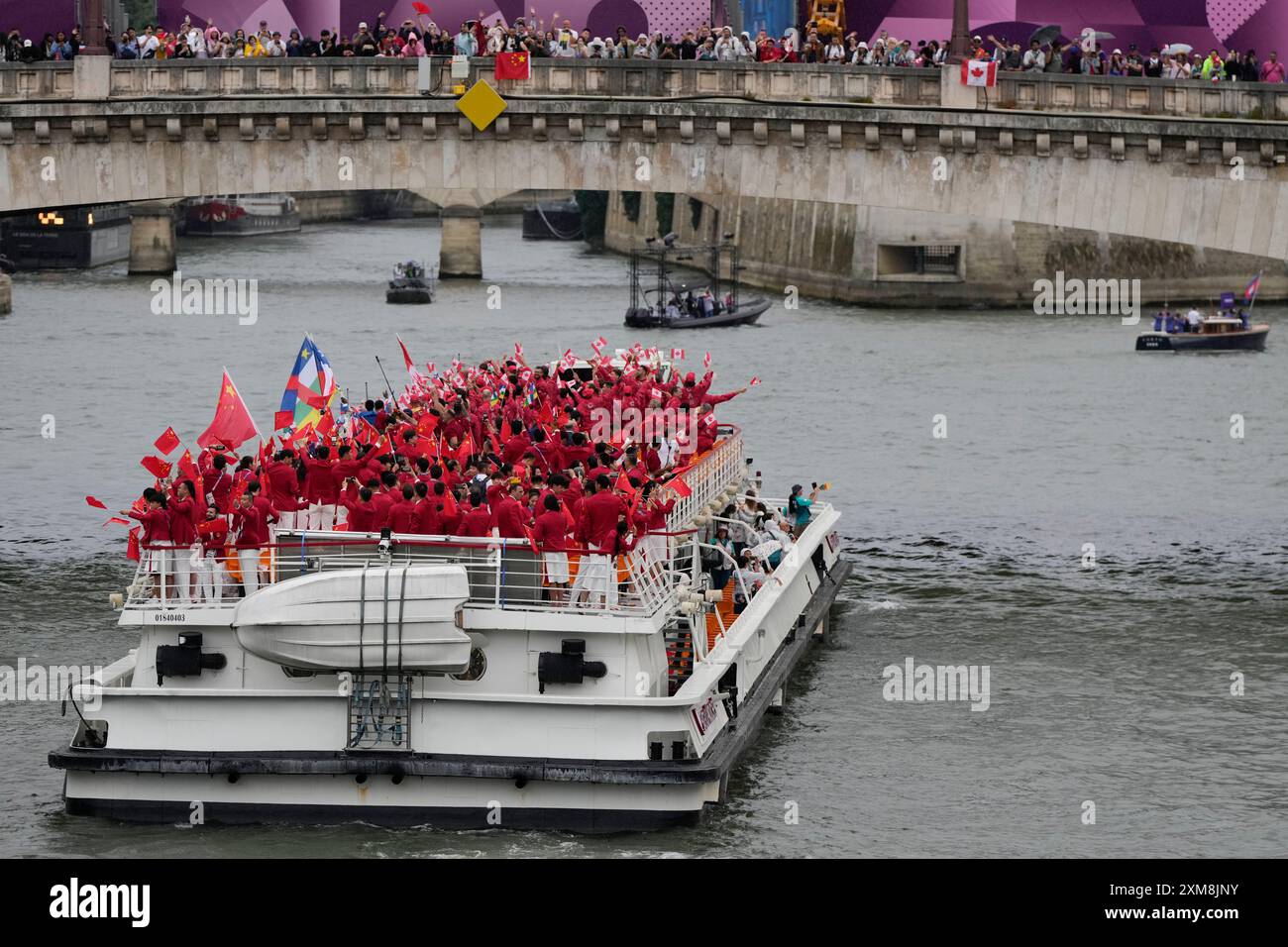 Athletes travel by boat down the Seine River in Paris, France, during ...