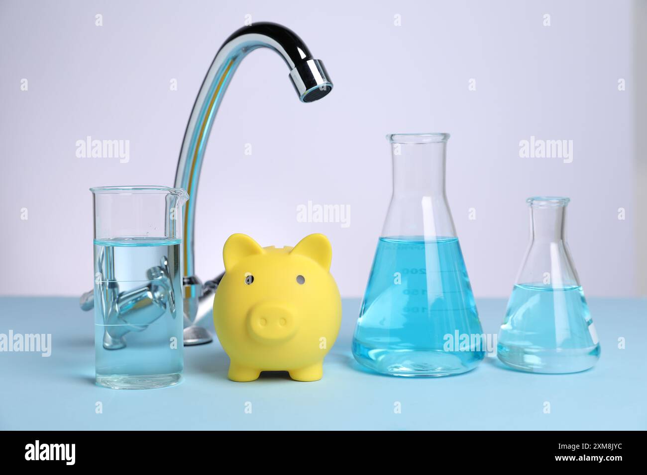 Water saving concept. Piggy bank, tap and glassware with liquid on ...