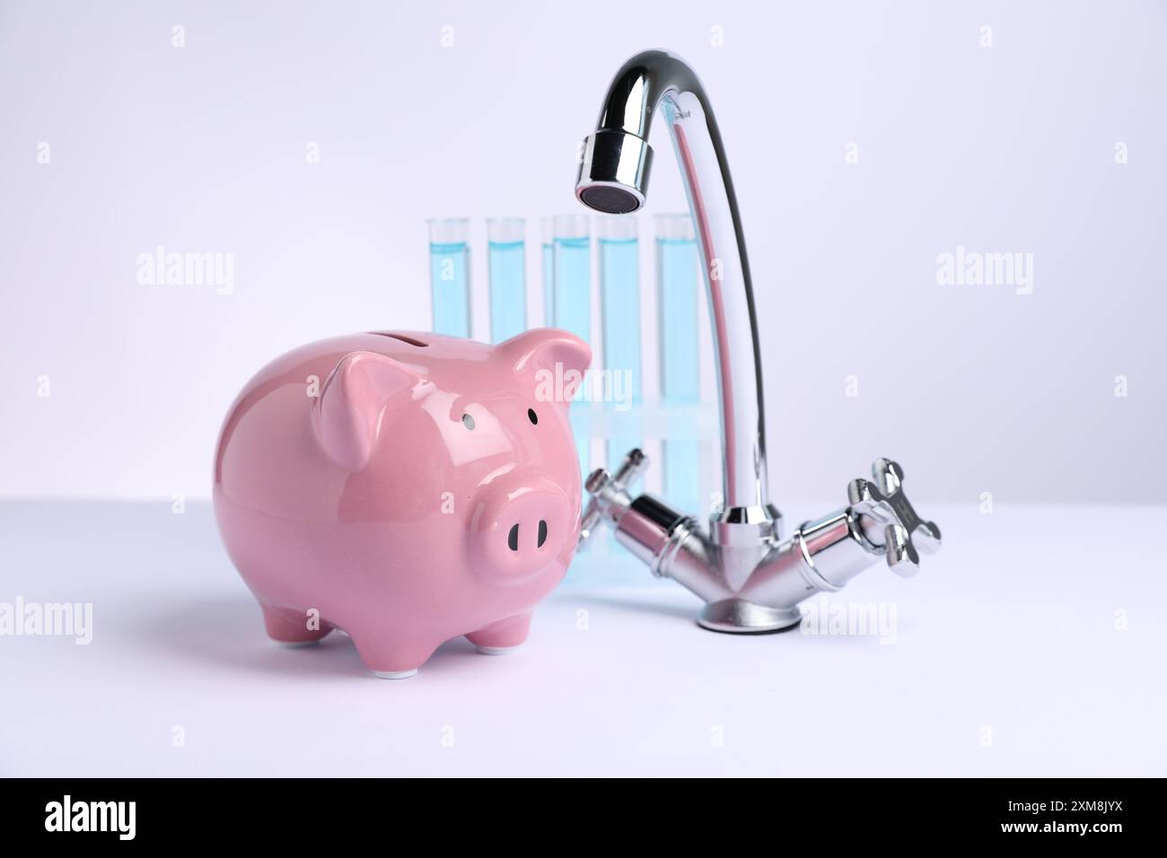 Water saving concept. Piggy bank, tap and test tubes with liquid on ...