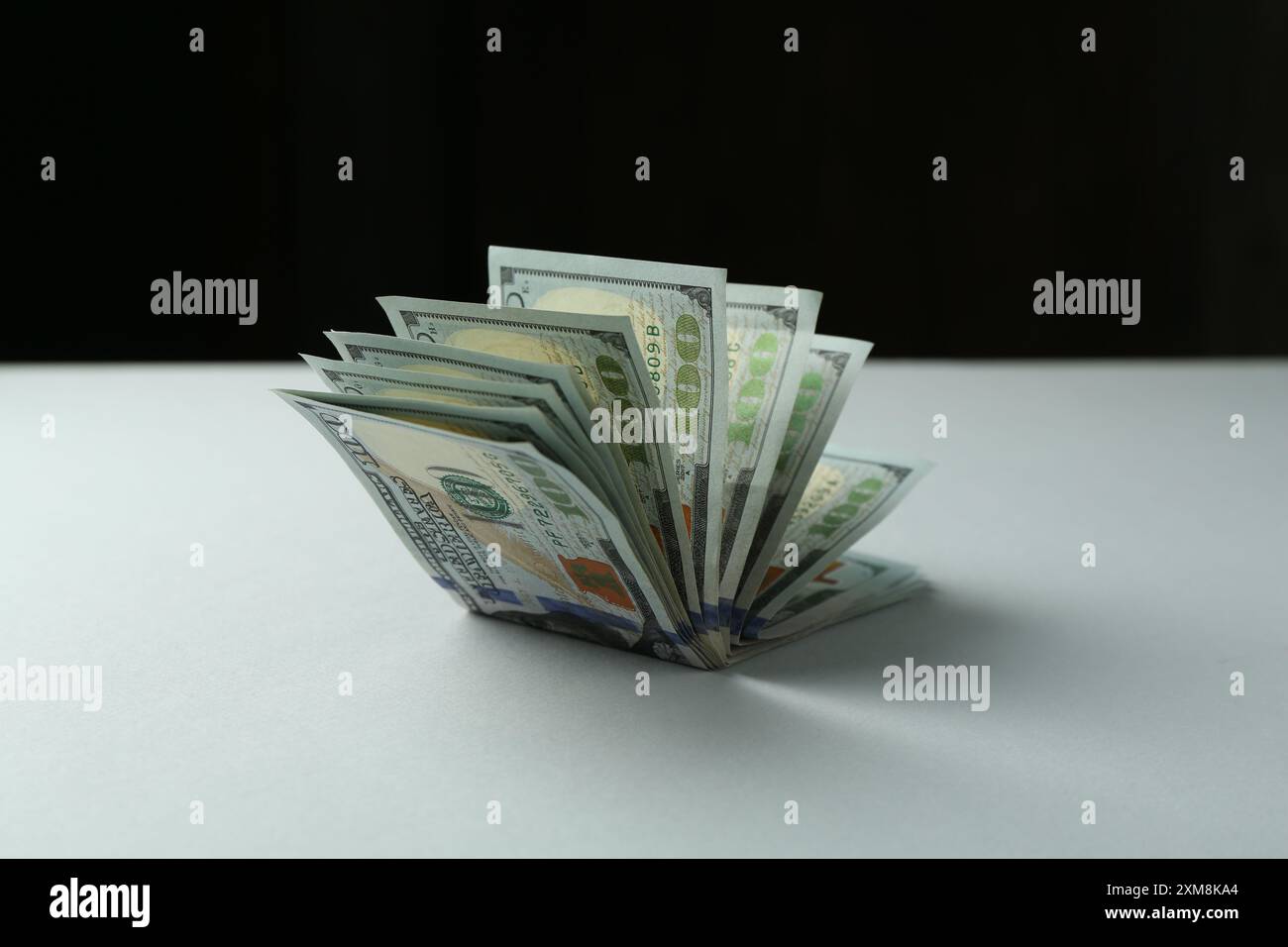 Dollar banknotes on grey table against black background Stock Photo - Alamy