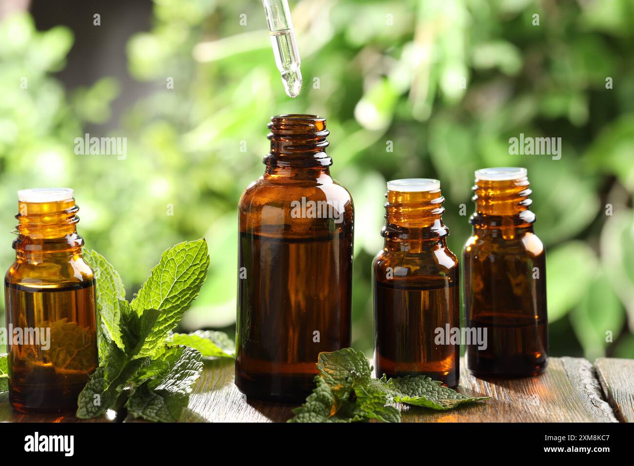 Essential oil dripping from pipette into bottle on table, closeup Stock ...