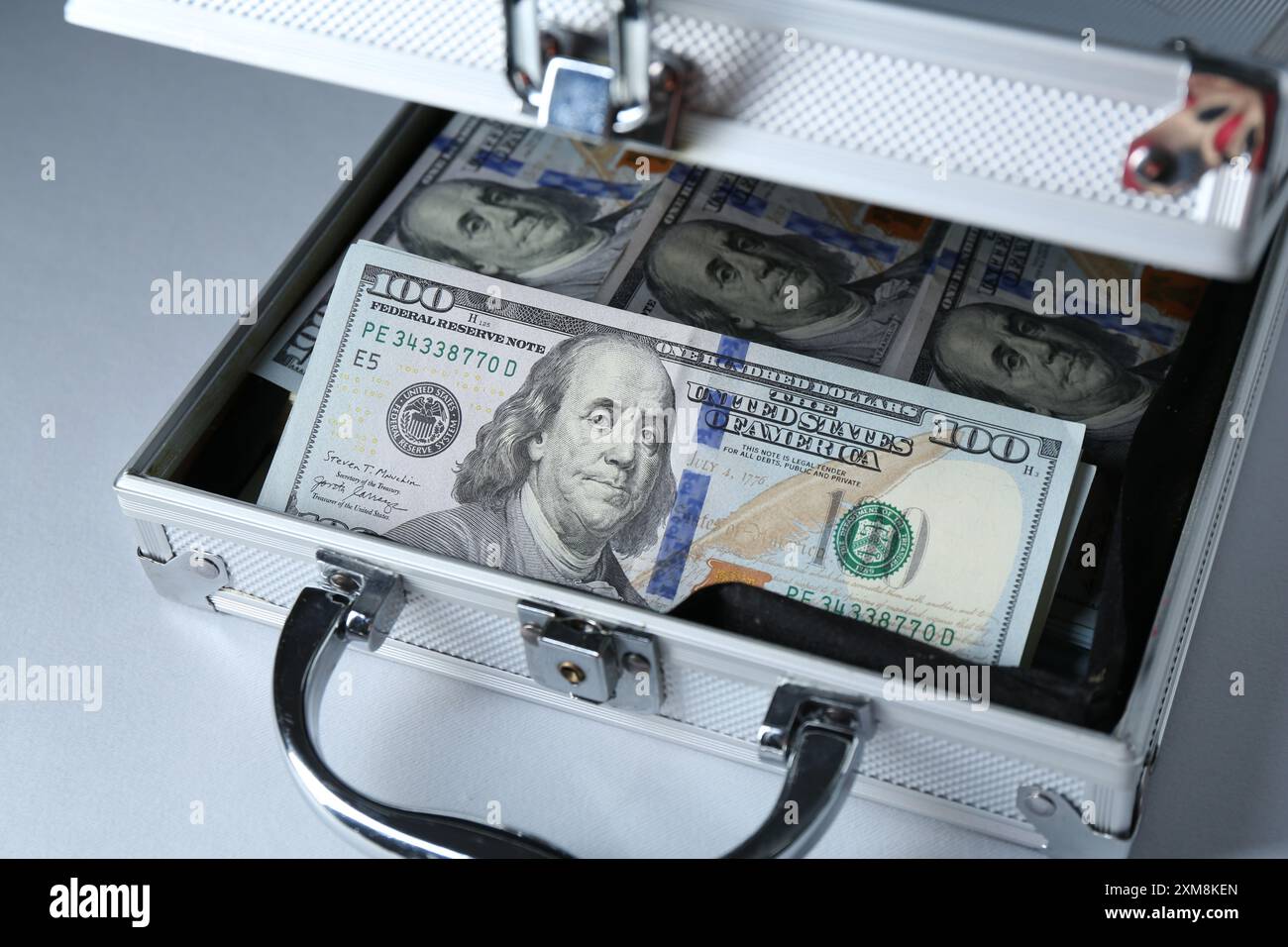 Metal case full of dollar banknotes on light background Stock Photo - Alamy