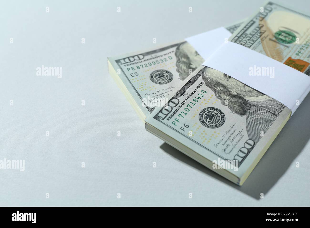 Bundles of dollar banknotes on light grey background, closeup. Space ...