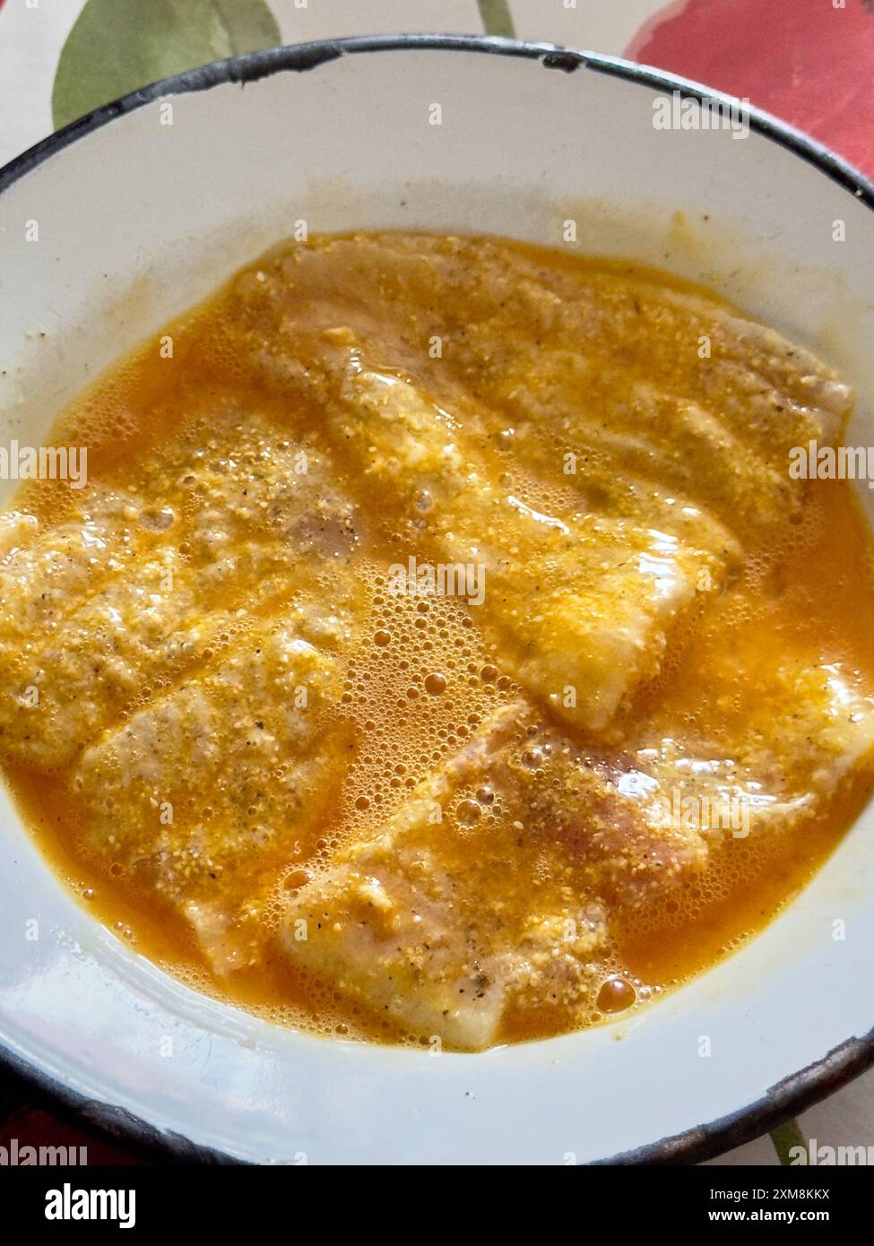 Marinated fish fillets in a bowl with seasoning ready to be cooked ...