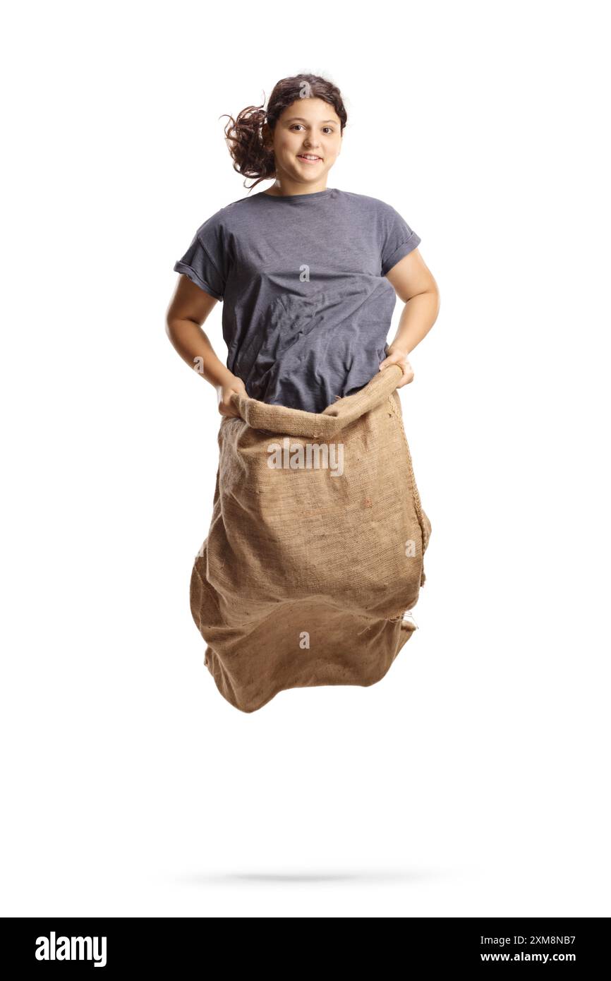 Happy teenage girl jumping in a sack and smiling isolated on white ...