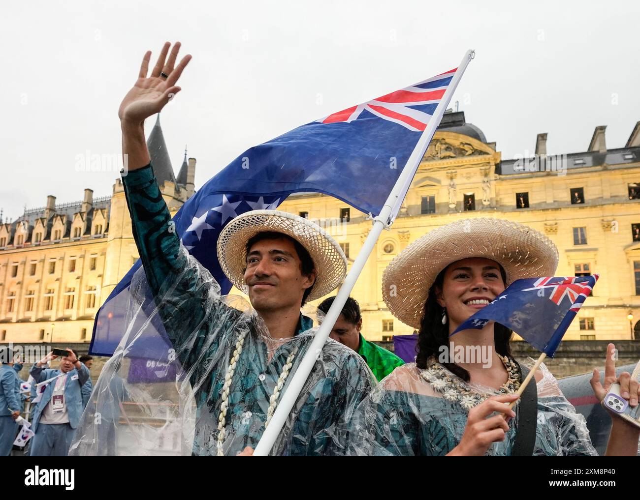 Cook Islands' Alex Beddoes and Lanihei Connolly wave their flag from a boat in Paris, France ...