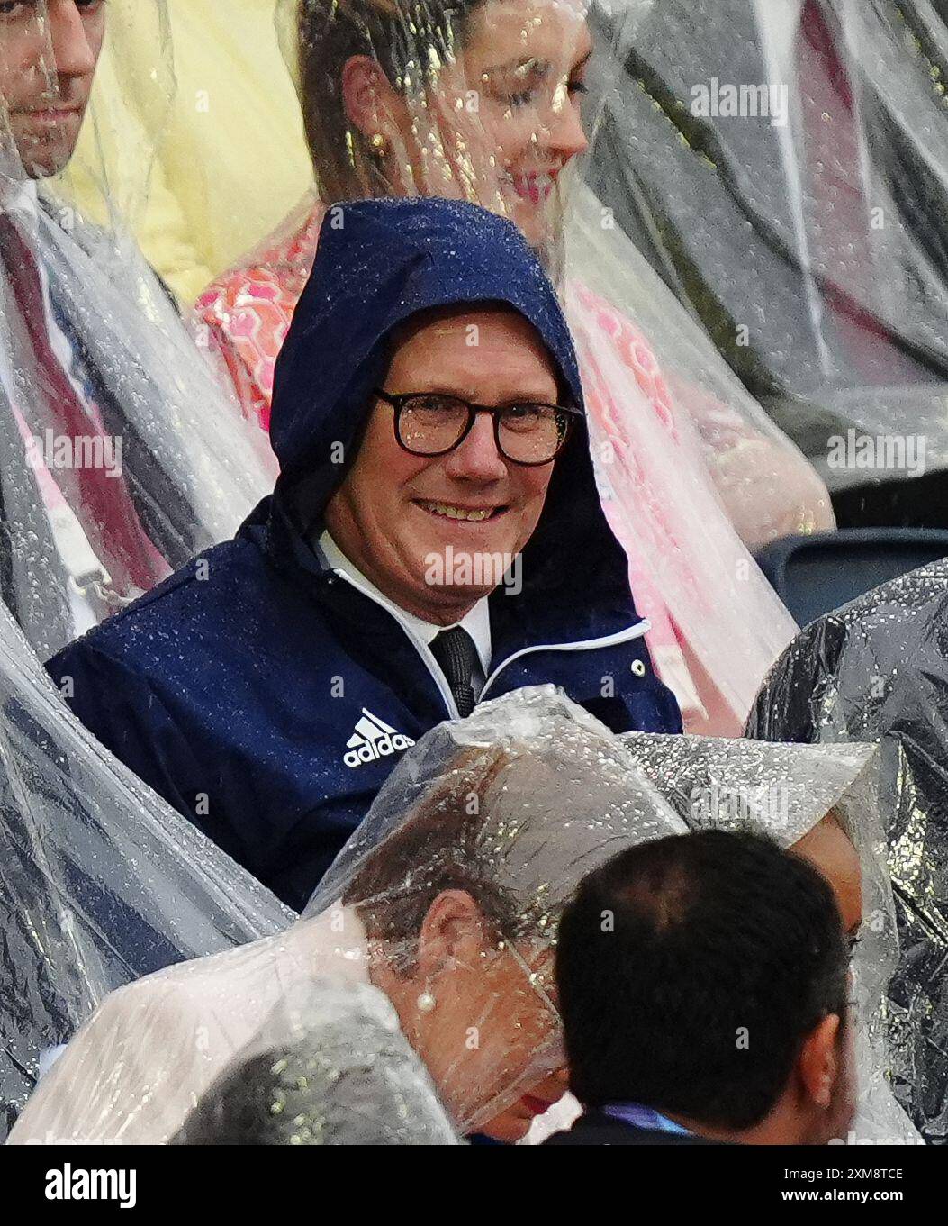 Prime Minister Sir Keir Starmer shelters from the the rain during the ...