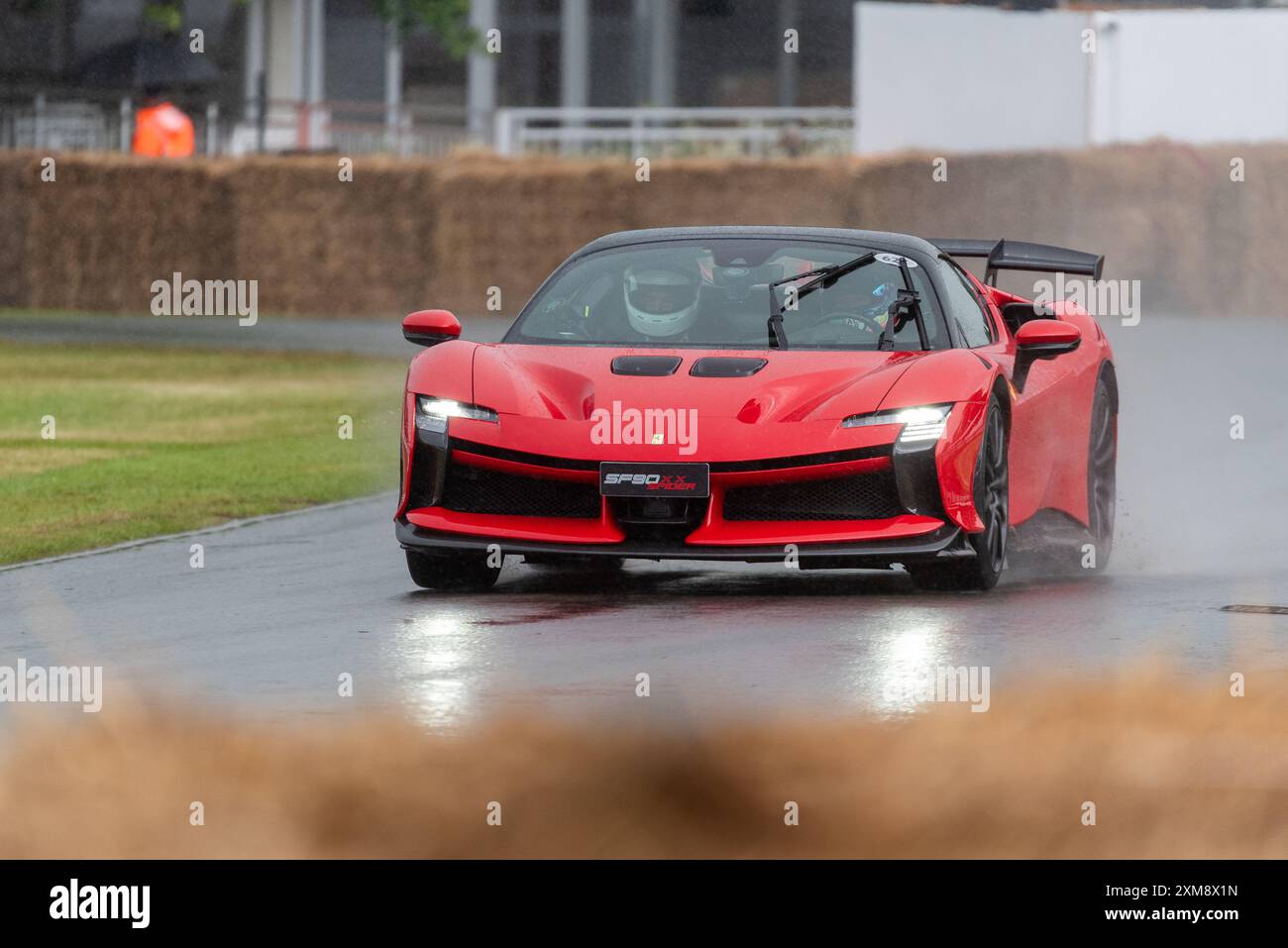 2022 Ferrari SF90 XX Spider hybrid sports car driving up the wet ...