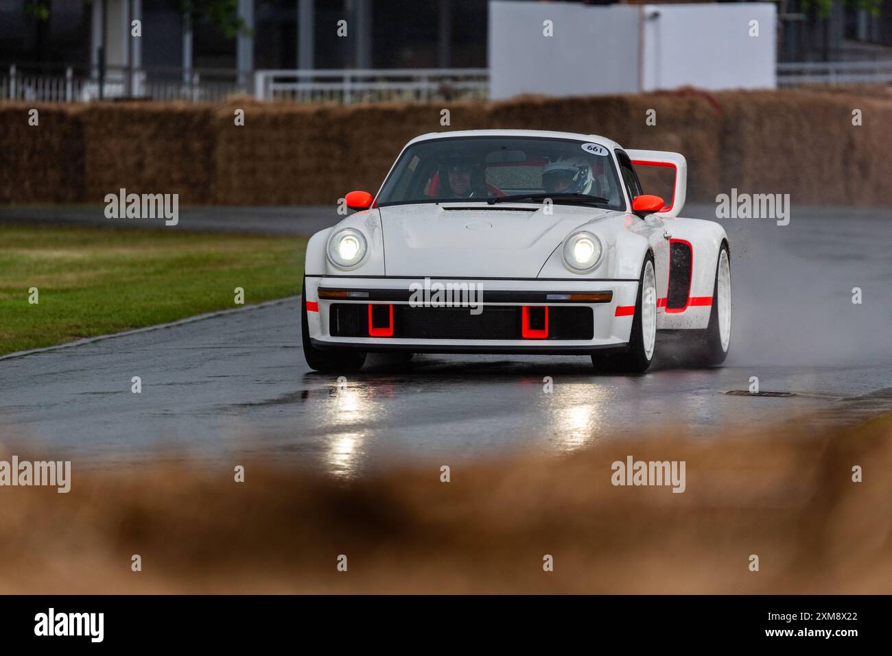1991 Porsche 911 Reimagined by Singer car driving up the wet hillclimb ...