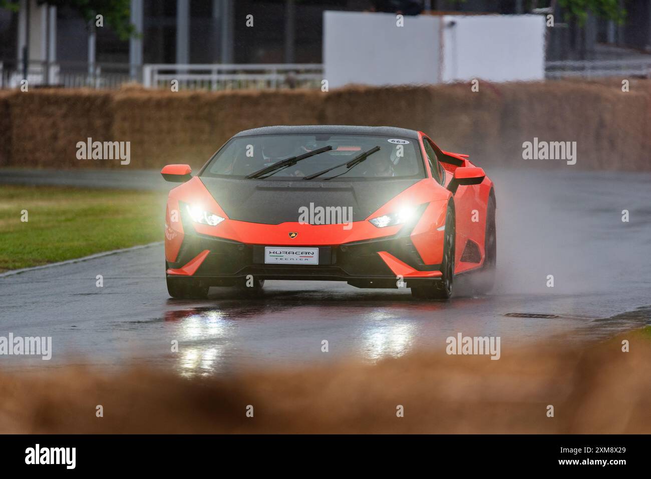 Lamborghini Huracán Tecnica sports car driving up the wet hillclimb track in heavy rain at the ...