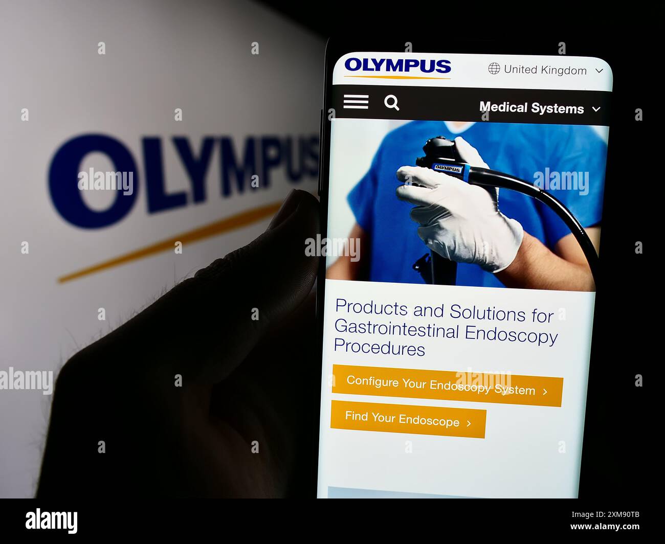 Person holding cellphone with webpage of Japanese optics company ...