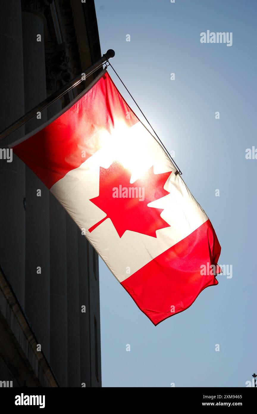 The Canadian flag hangs down from a building in downtown Ottawa, Ontario, Canada, with a ...