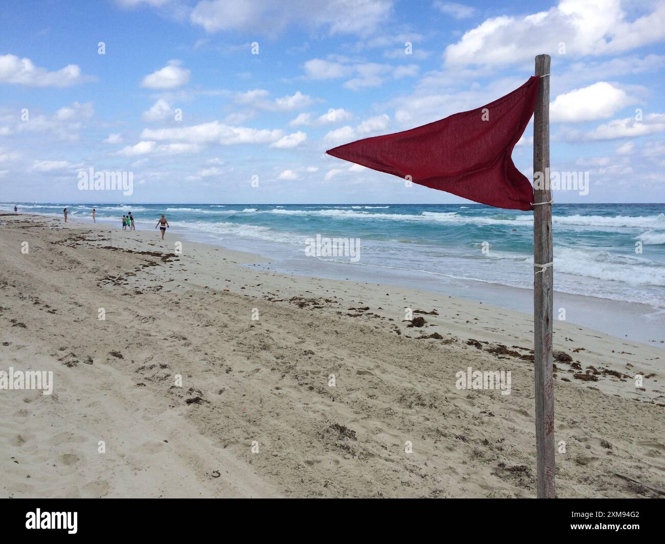 A red flag flies on a Cuban beach warning of high hazardous conditions ...