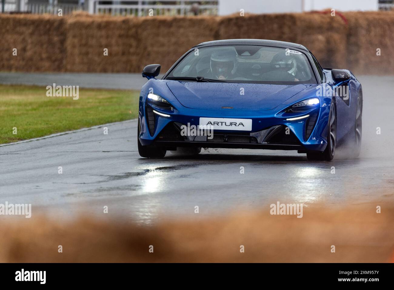 2024 McLaren Artura Spider hybrid sports car driving up the wet ...