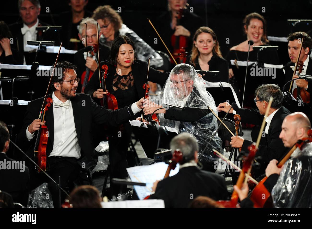 Musicians from the French National Orchestra shelter from the rain ...