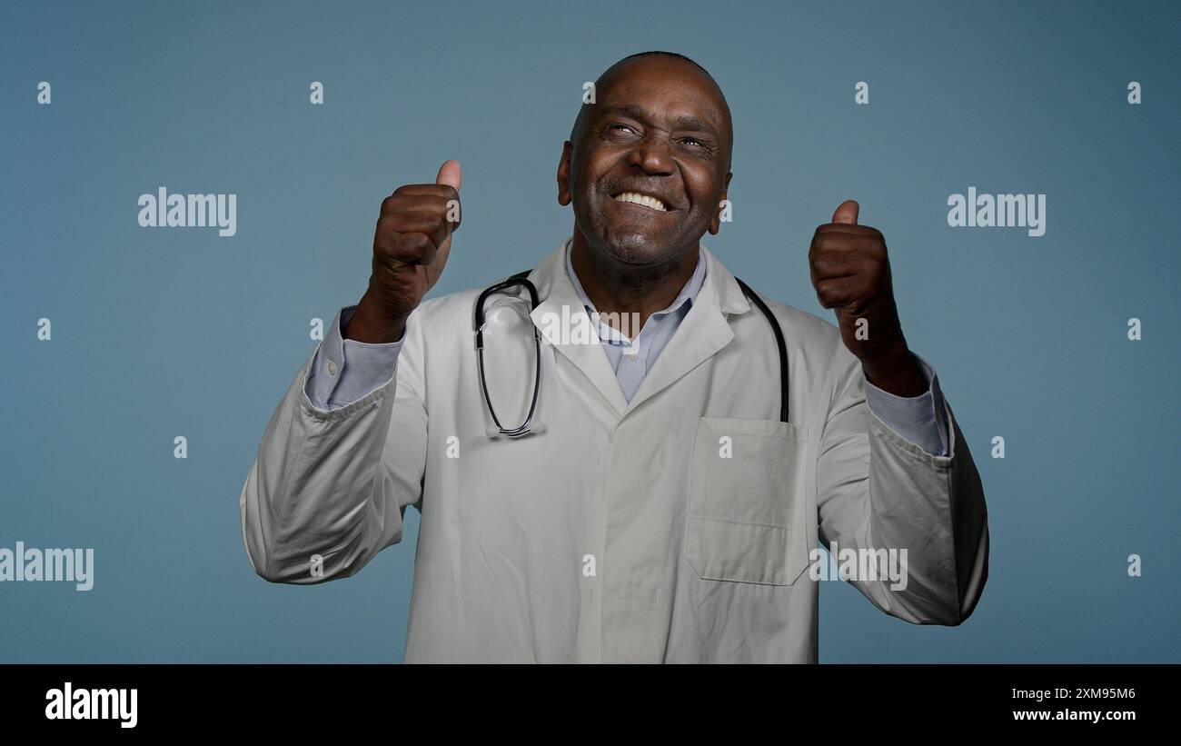 Happy joyful african american man doctor showing thumb up in studio ...