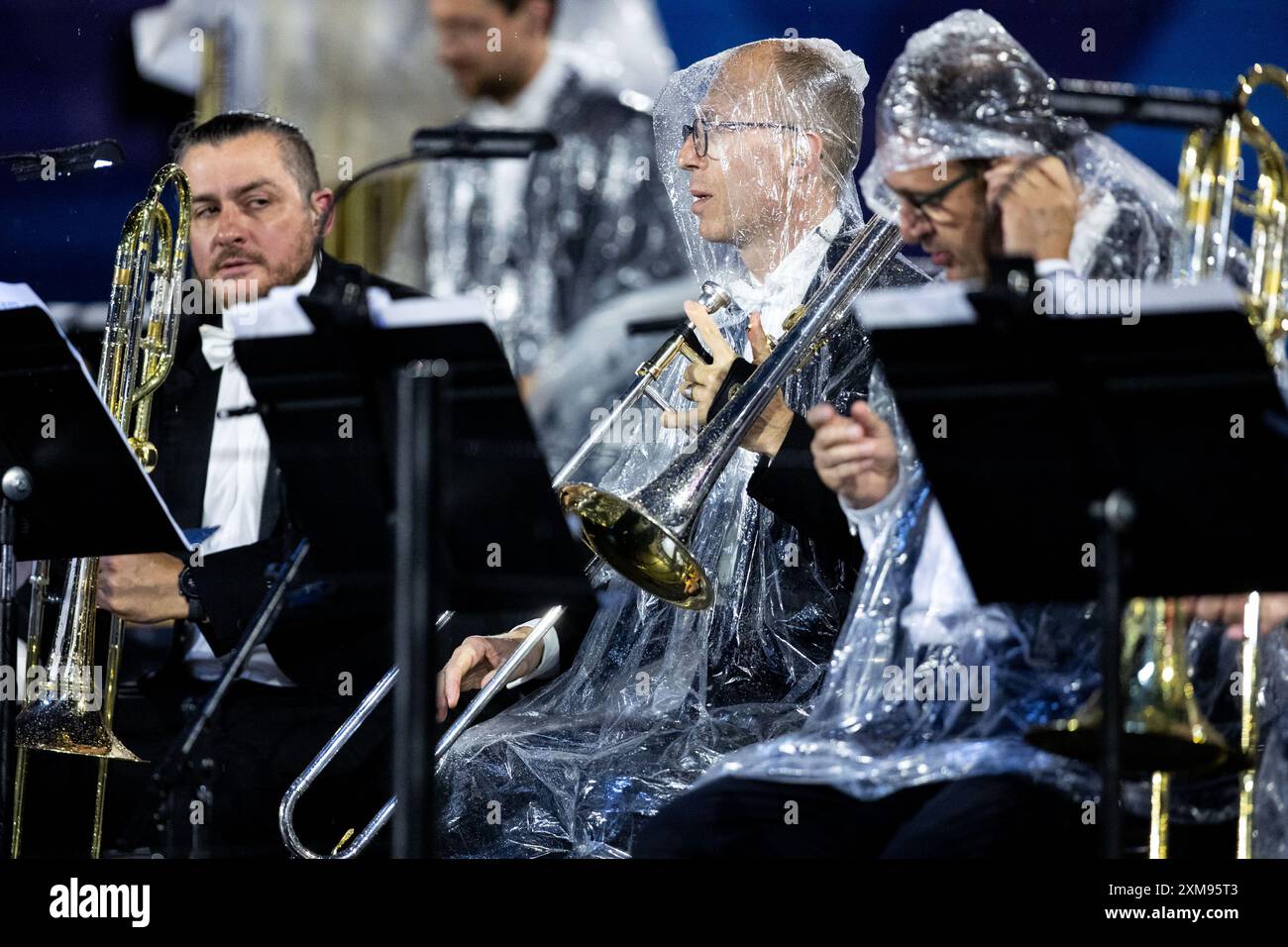 Musiker des Orchester im Regen im Regenponcho mit Instrumenten, FRA ...