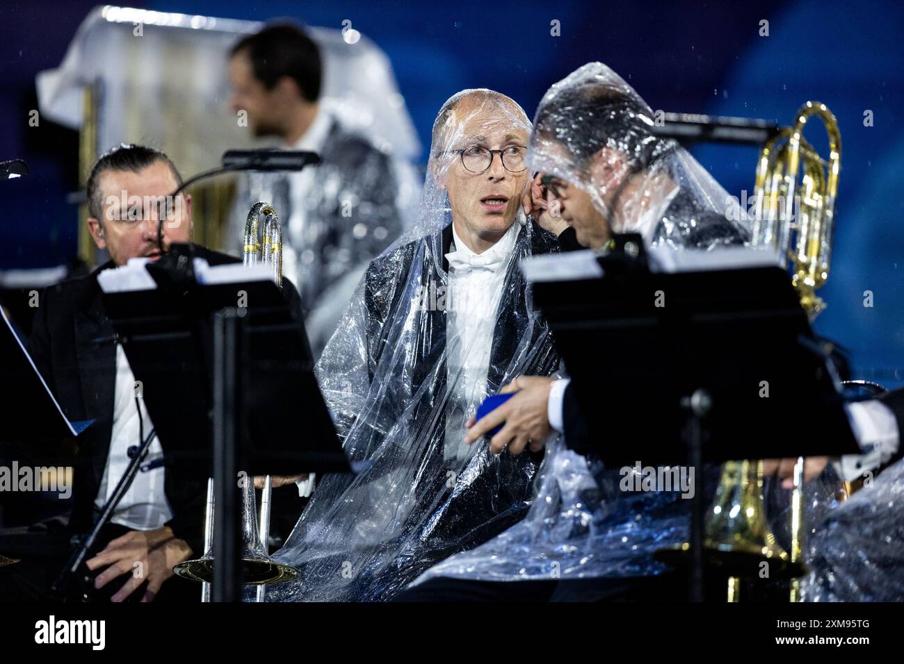 Musiker des Orchester im Regen im Regenponcho mit Instrumenten, FRA ...
