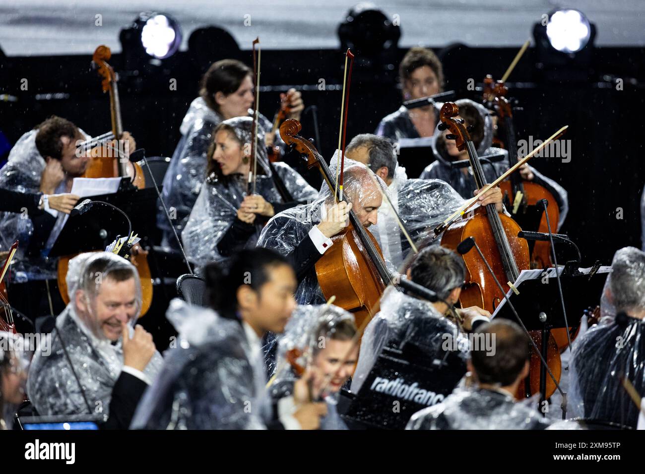 Musiker des Orchester im Regen im Regenponcho mit Instrumenten, FRA ...