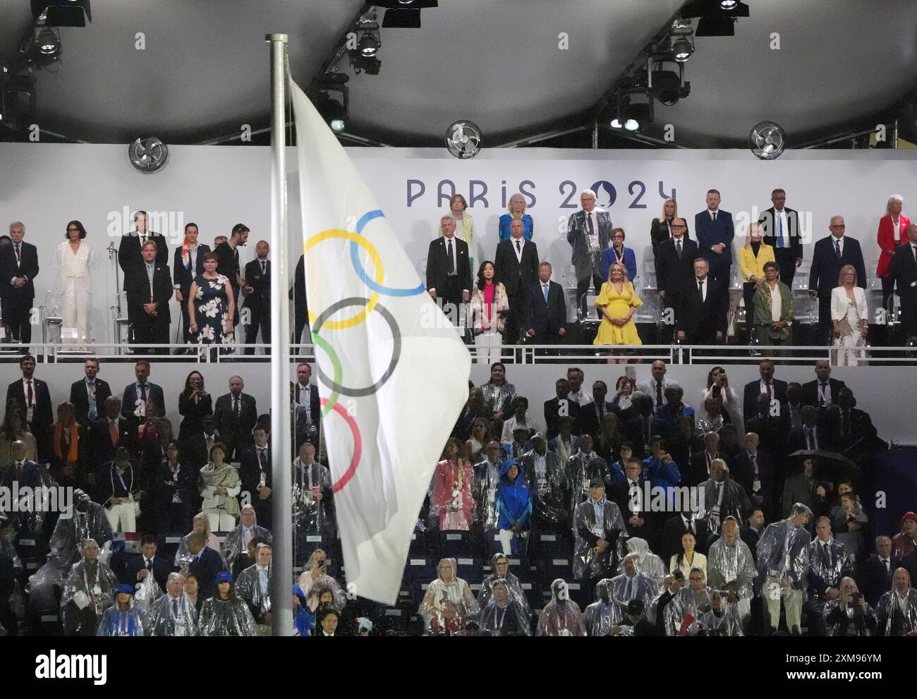 Paris, France. 26th July, 2024. Dignitaries stand as the Olympic flag ...