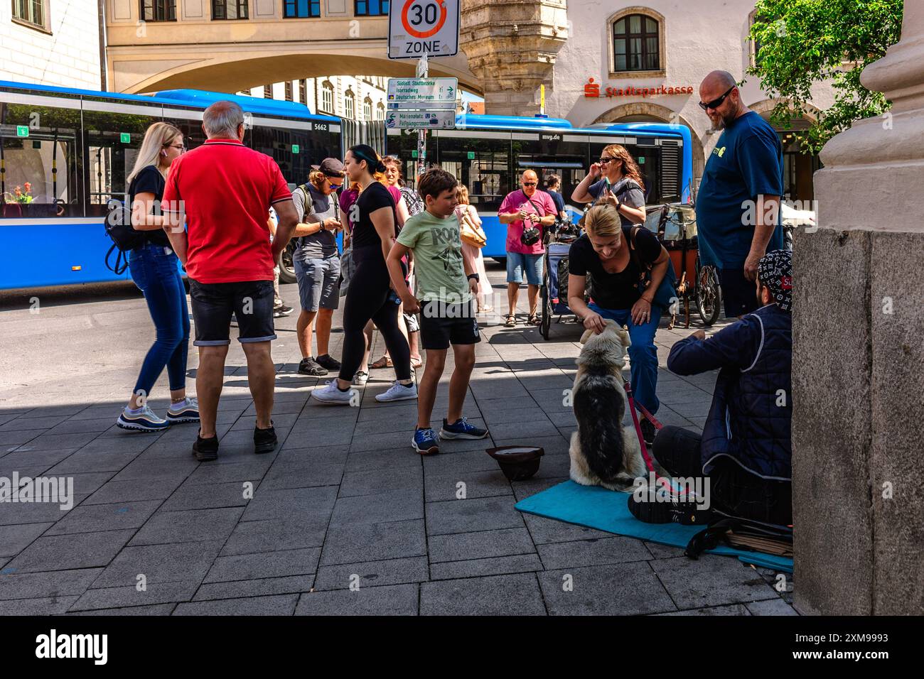 Munich, Germany - July 22, 2023: People feed homeless man and his dog ...