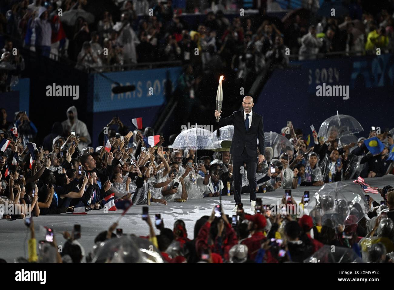 Paris, France. 26th July, 2024. Zinédine Zidane carries the Olympic ...