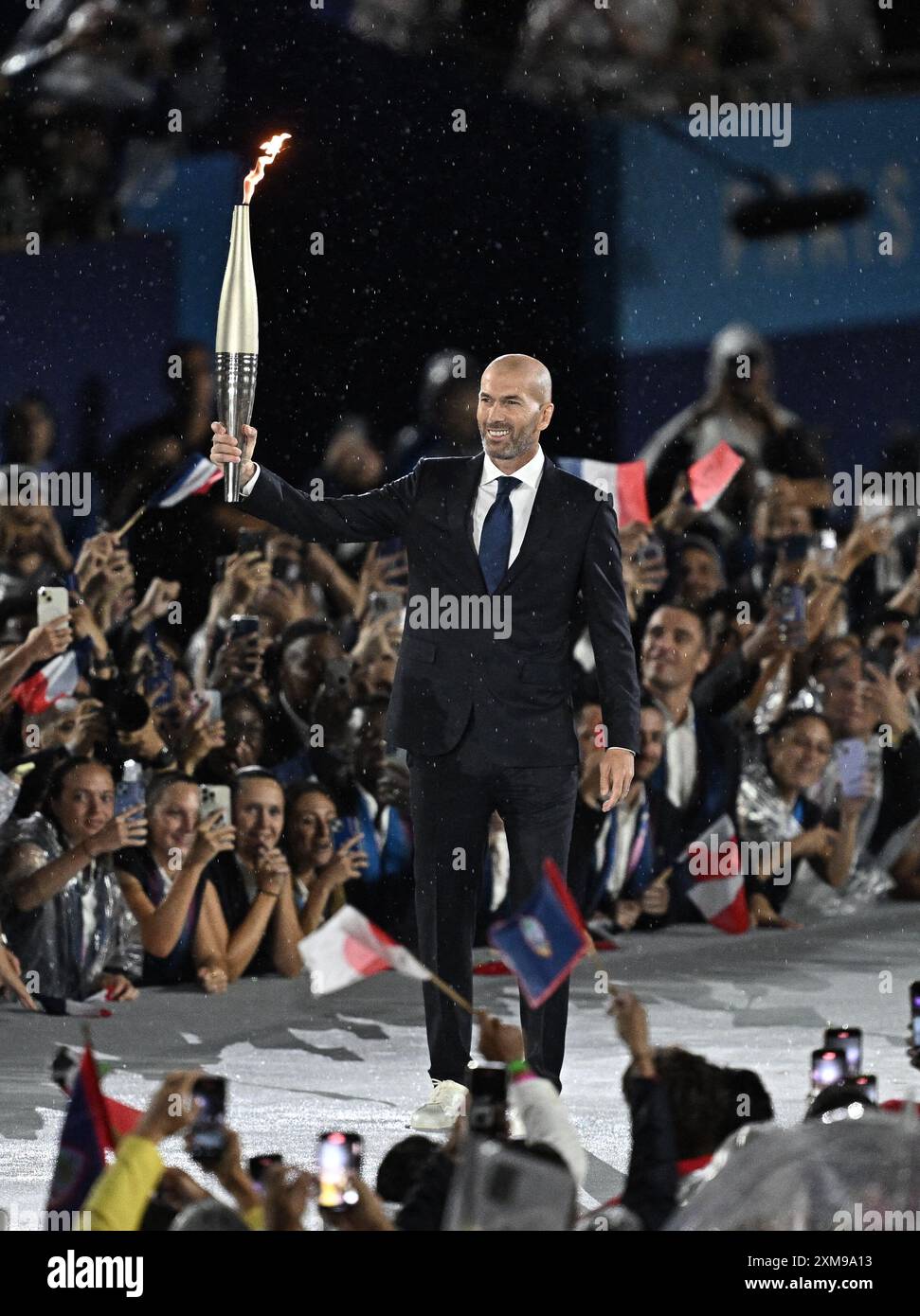 Paris, France. 26th July, 2024. Zinédine Zidane carries the Olympic ...