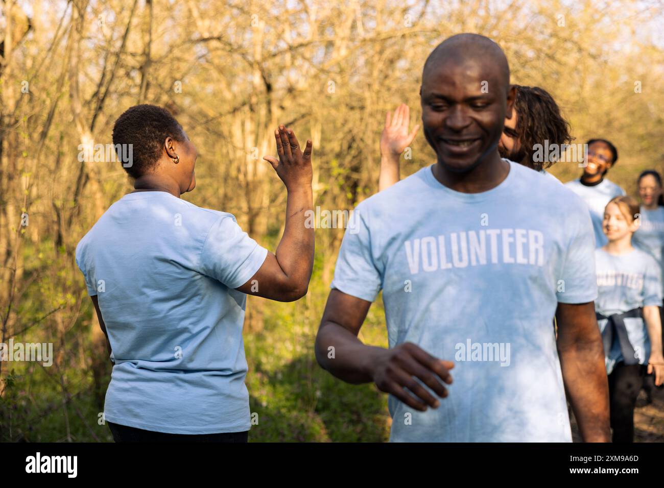 Team of volunteers sharing high five praising each other after a ...