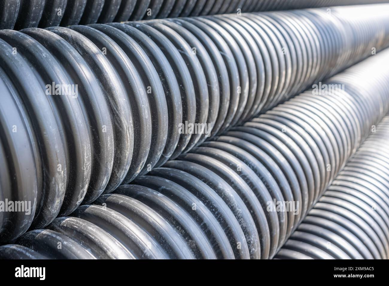 Stack of black HDPE storm sewer pipe (HDPE plastic N-12) on a project ...