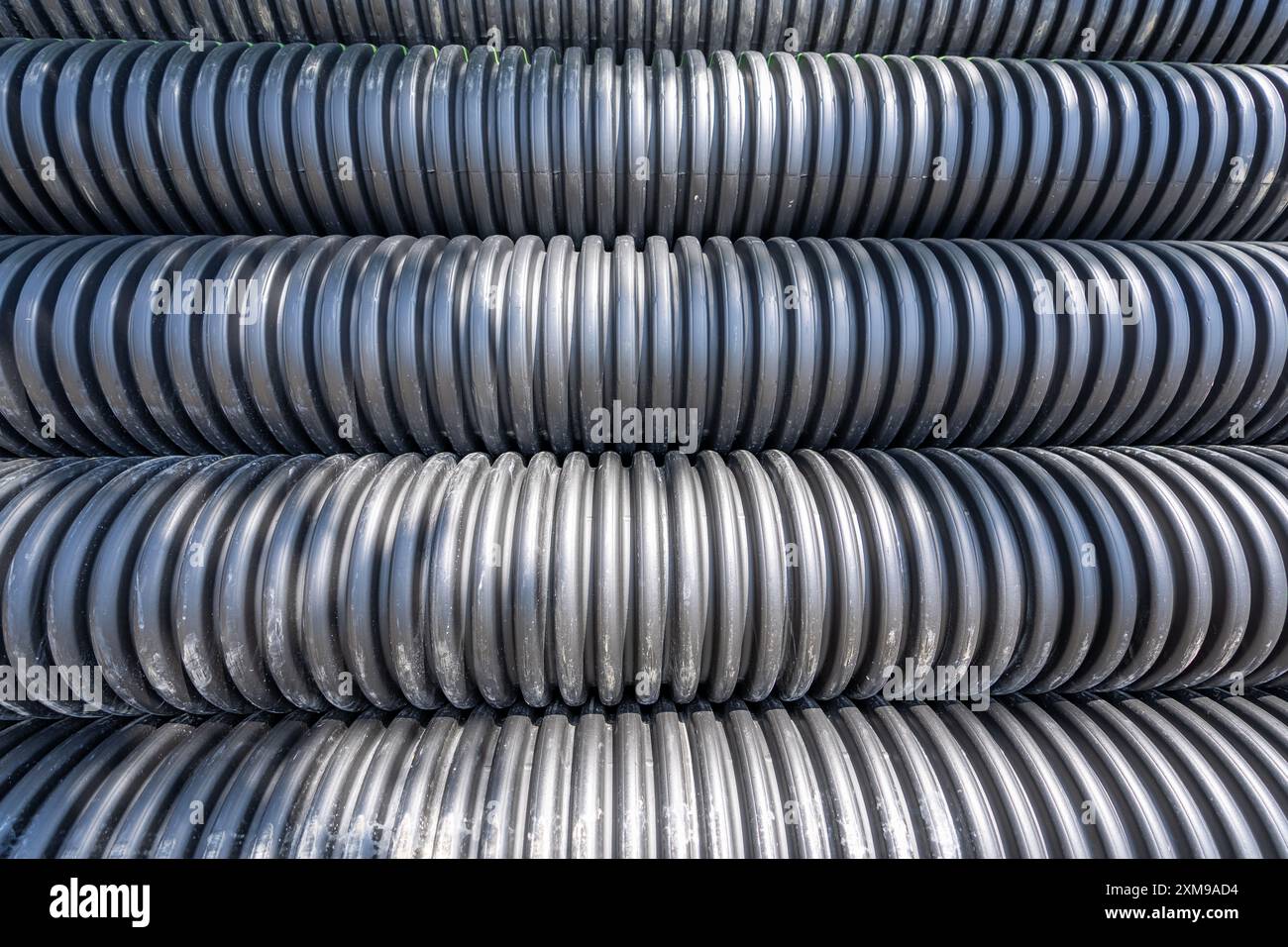 Stack of black HDPE storm sewer pipe (HDPE plastic N-12) on a project ...