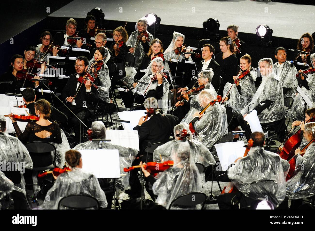 Musicians from the French National Orchestra shelter from the rain ...
