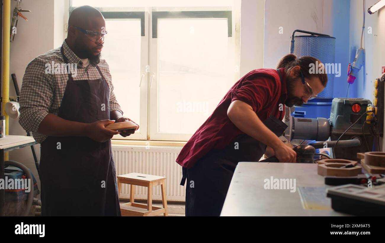 Carpenter making modifications on blueprint drawings, using angle ...