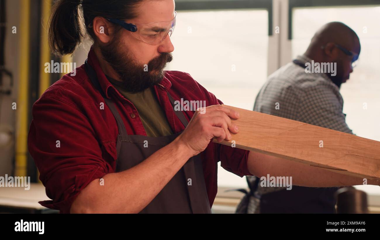 Carpenter putting safety glasses on while selecting quality wood ...