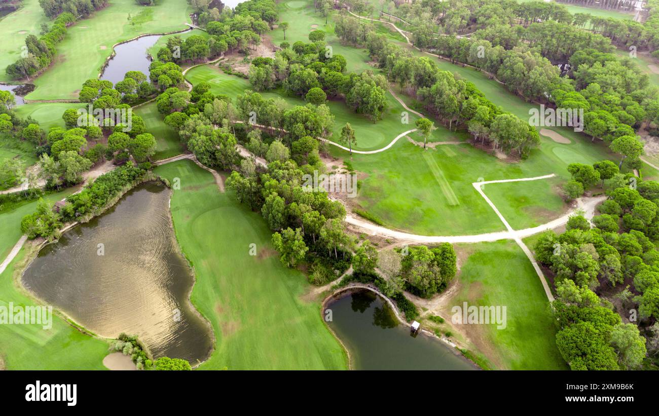 Aerial view of golf course at sunset with beautiful trees, pond and ...