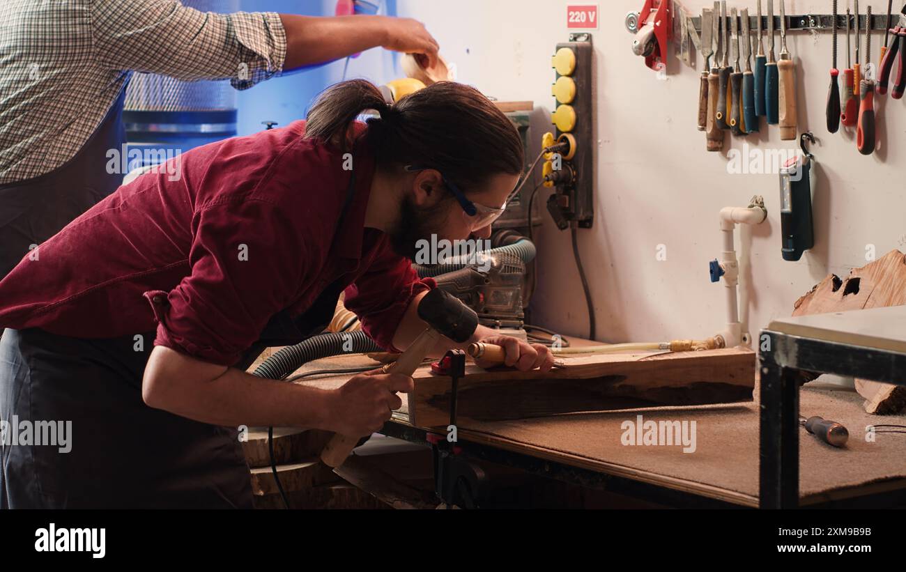 Woodworker using bench vise to hold lumber block, carving intricate ...