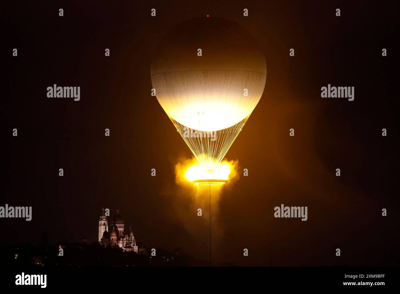The cauldron, with the Olympic flame lit, lifts off while attached to a ...