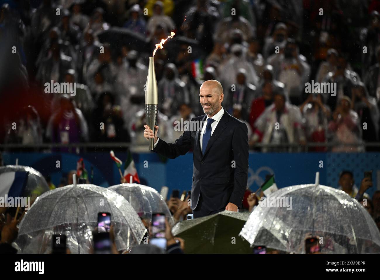 Paris, France. 26th July, 2024. Zinedine Zidane carries the Olympic ...