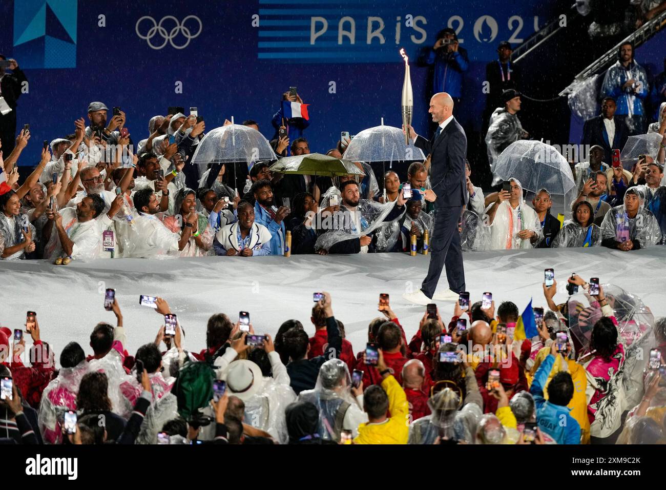 Zinedine Zidane carries the torch in Paris, France, during the opening ...
