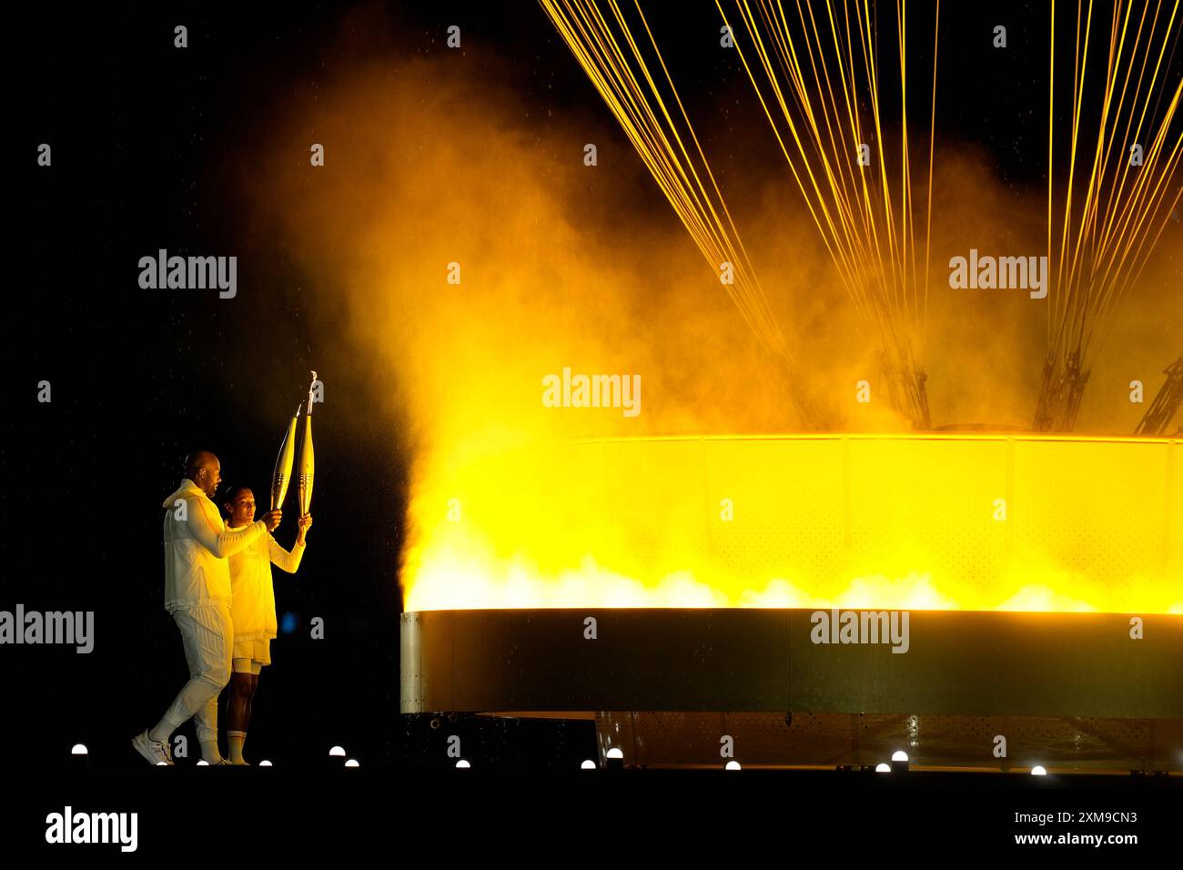 The cauldron is lit by torch bearers Marie-Jose Perec and Teddy Riner ...