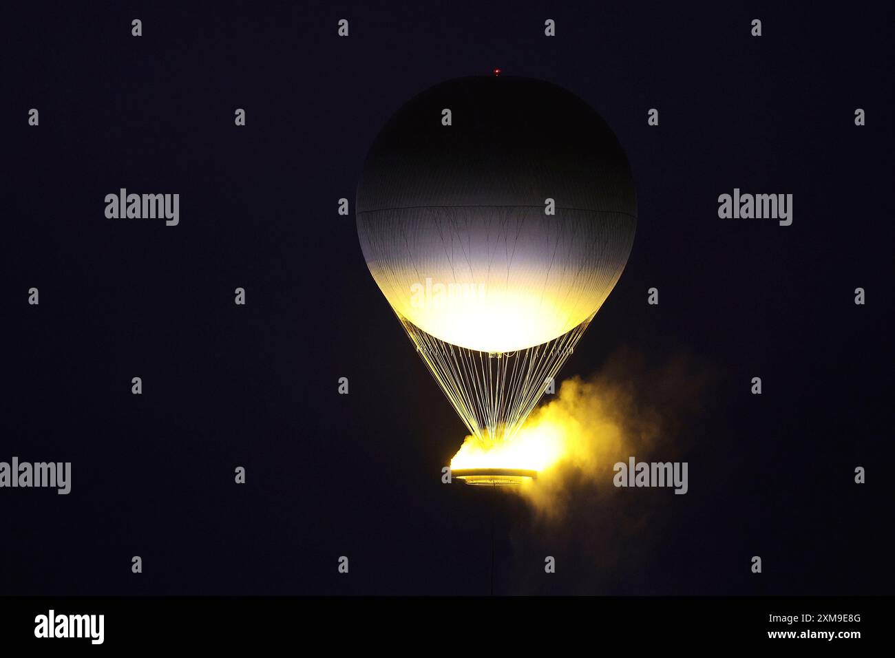 A balloon carrying the Olympic Cauldron rises in the sky after being ...